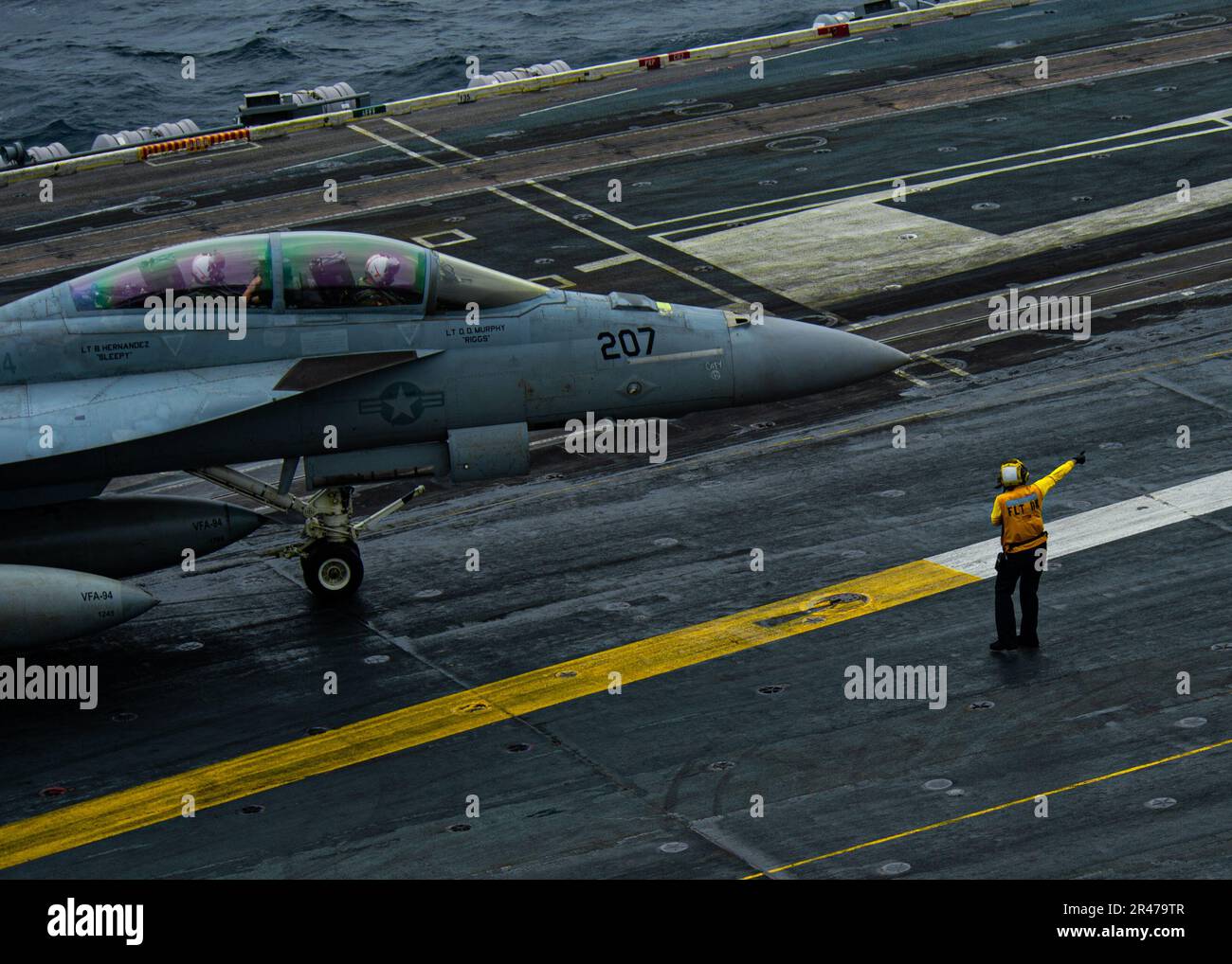 230130-N-MH015-1042 SOUTH CHINA SEA (Jan. 30, 2023) A U.S. Navy Sailor directs an F/A-18F Super ...