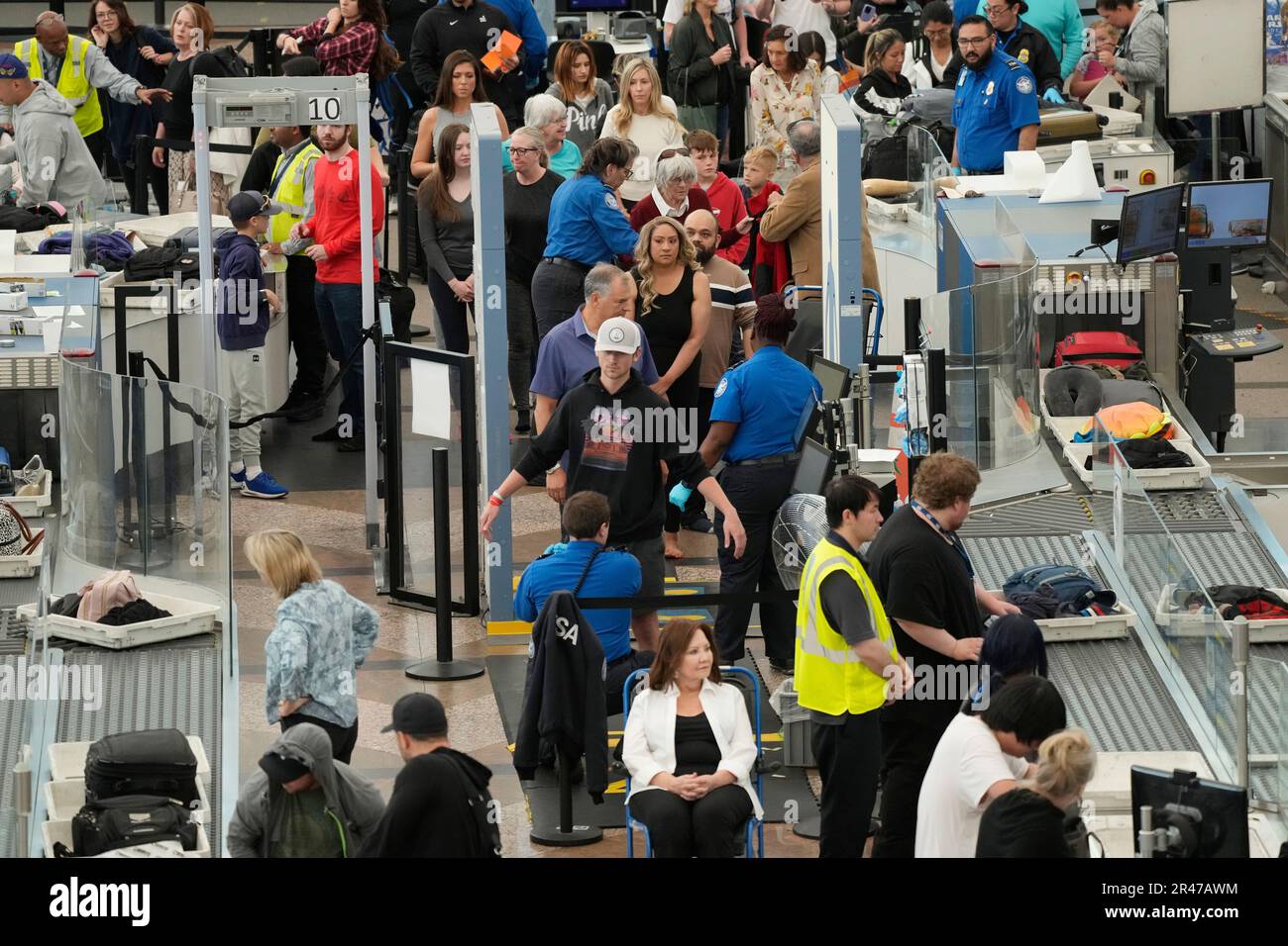 Travelers line up at a security checkpoint in the Denver International ...
