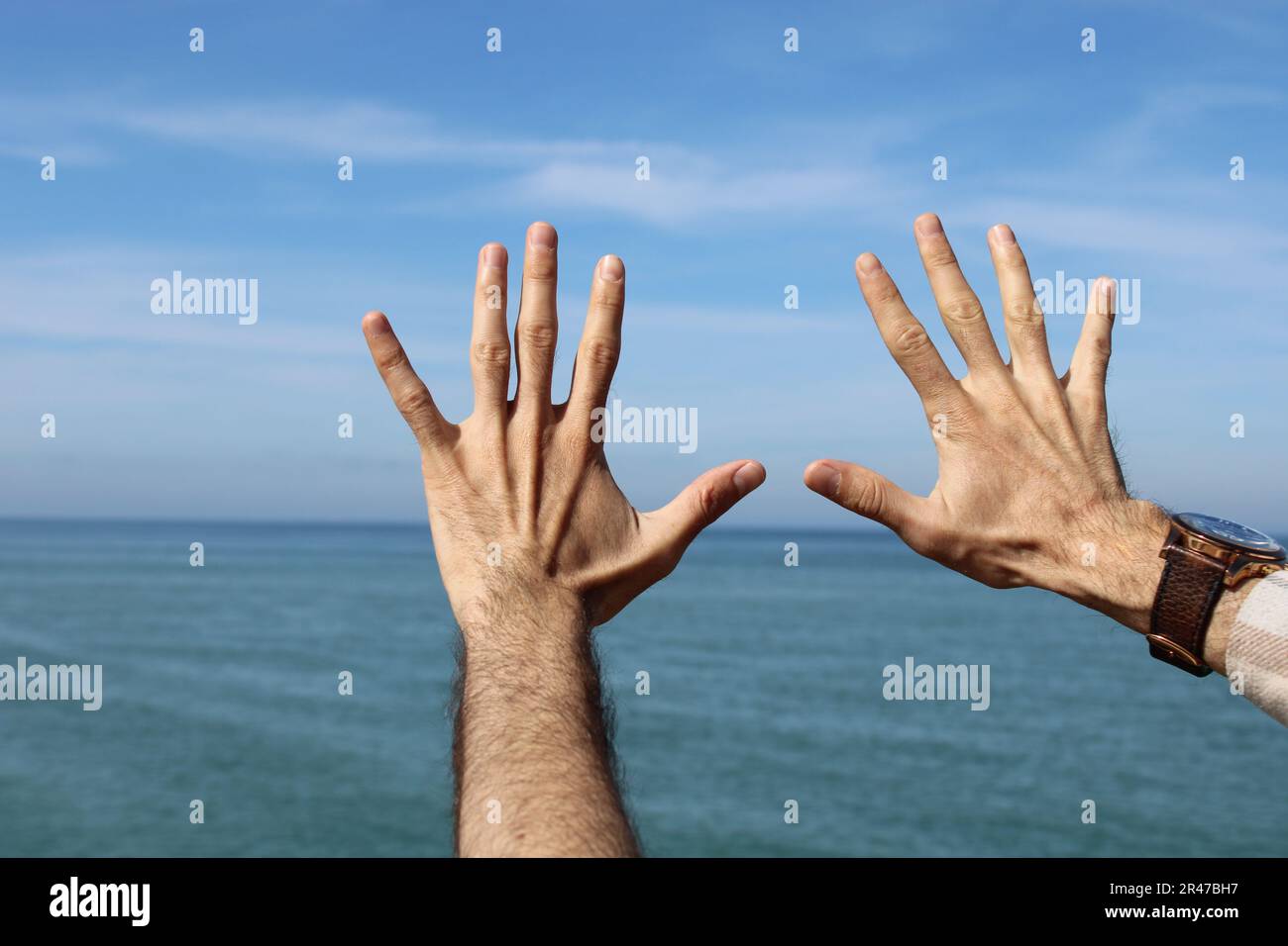 Hand doing,showing number ten gesture symbol on blue summer sky nature ...