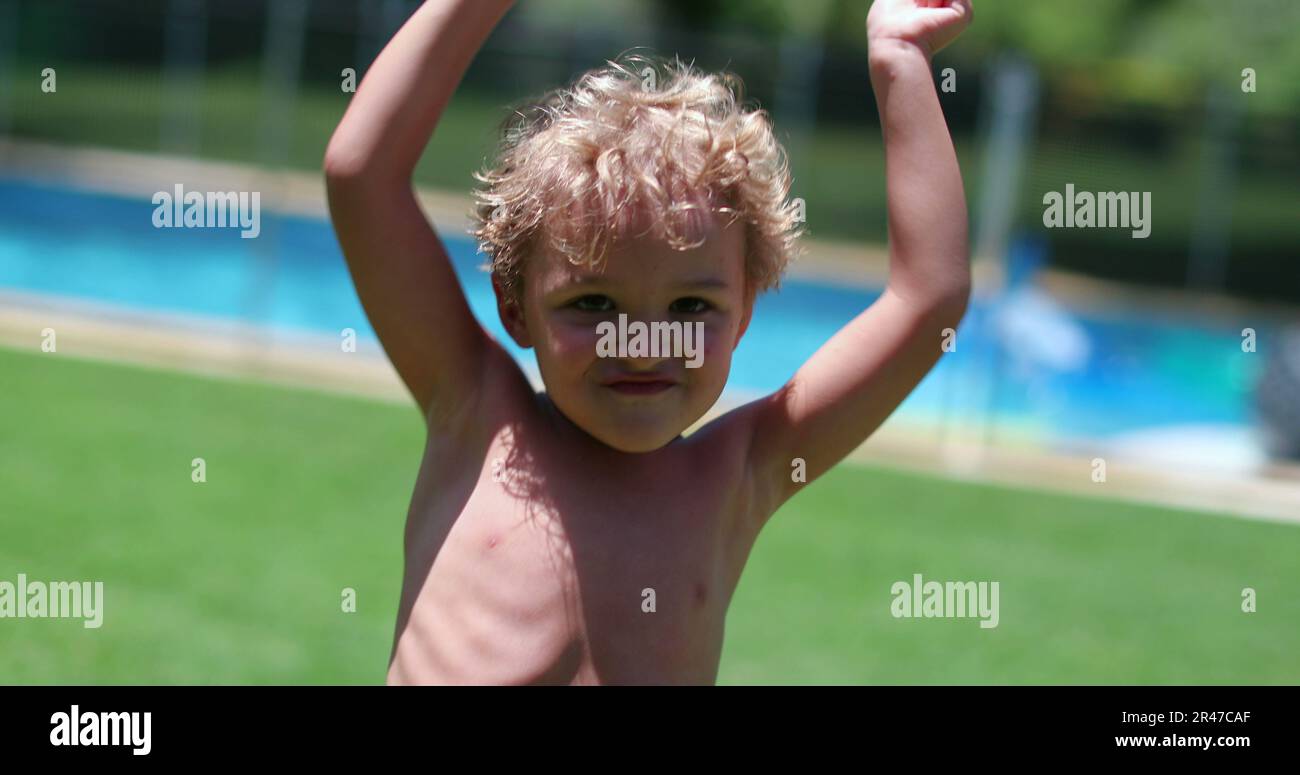 Cute toddler baby boy raising arms in the air celebrating Stock Photo ...