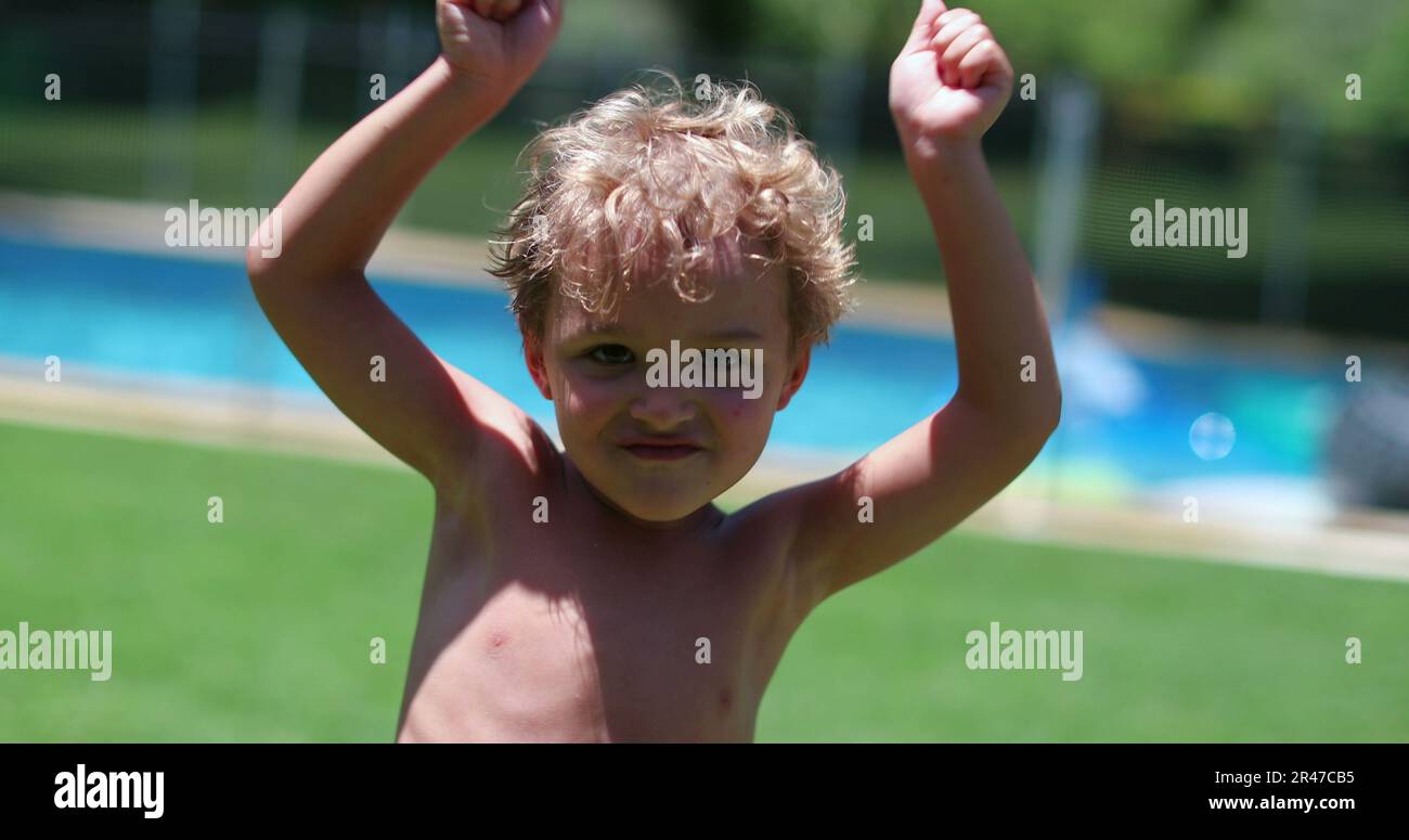 Cute toddler baby boy raising arms in the air celebrating Stock Photo ...