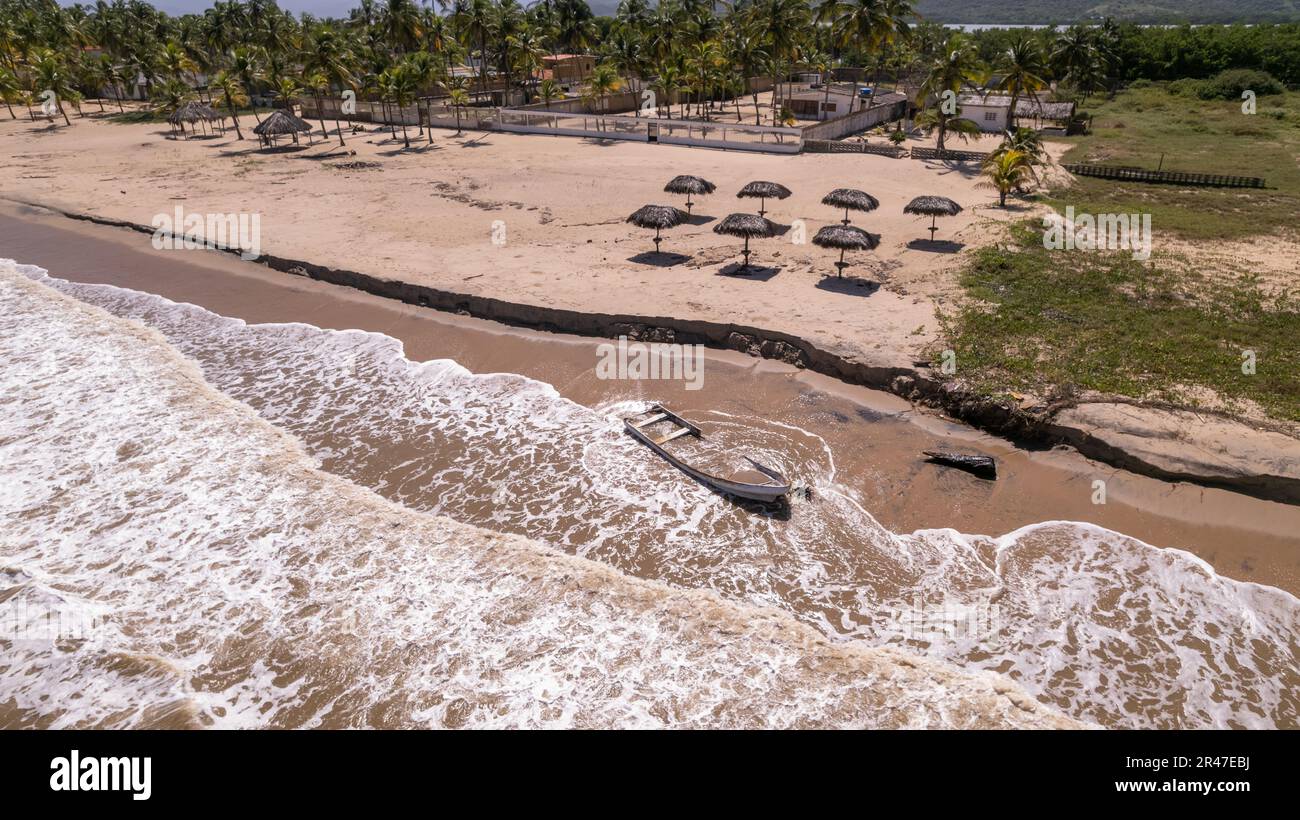 Sunken small fishing boat buried in the sand on a coast of the ...