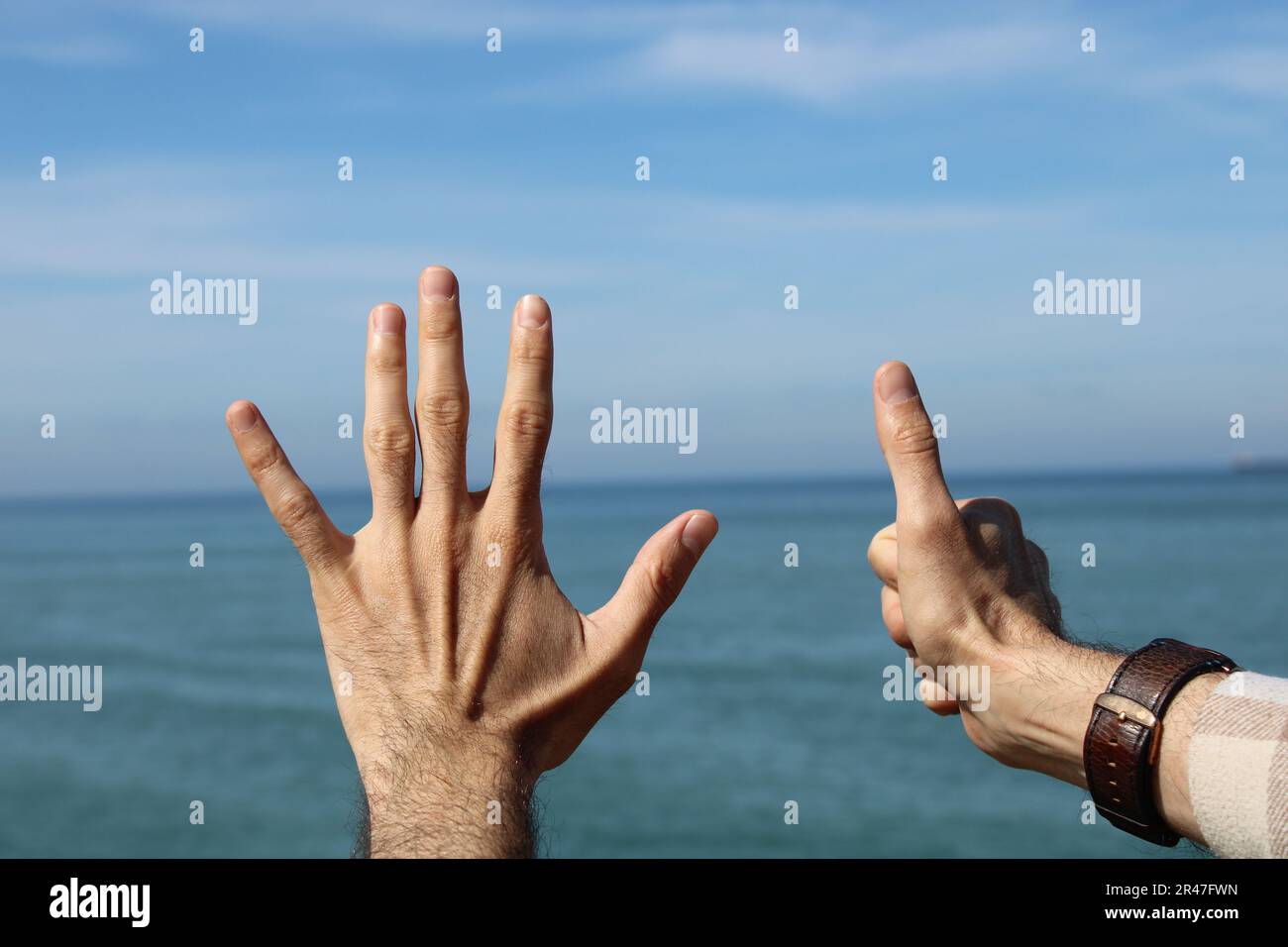 Hand doing,showing number gesture symbol six on blue summer sky nature ...