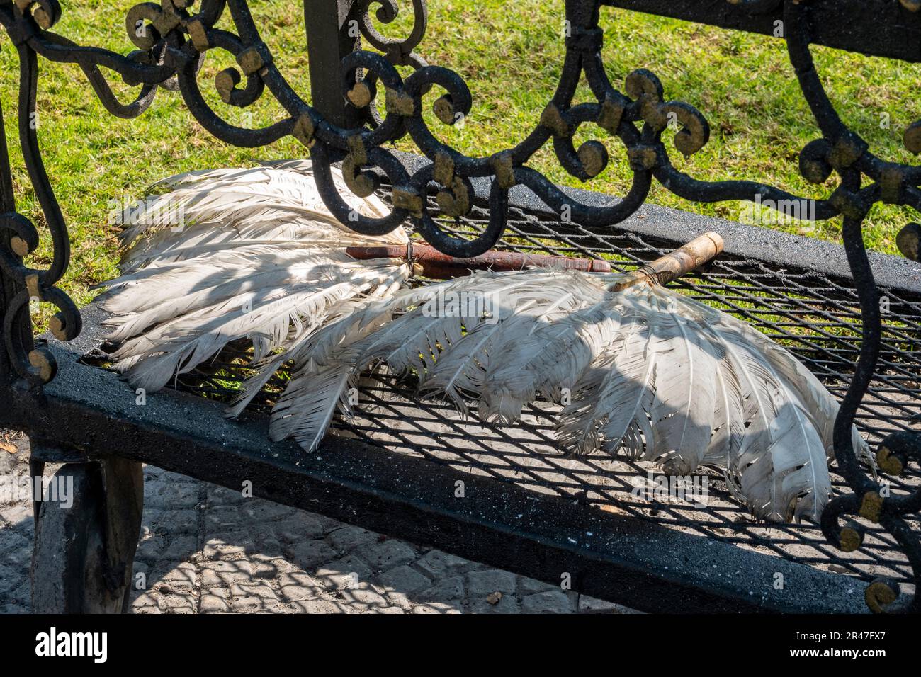 Two, home made, feather fans used to draw flames from a hotel barbeque ...