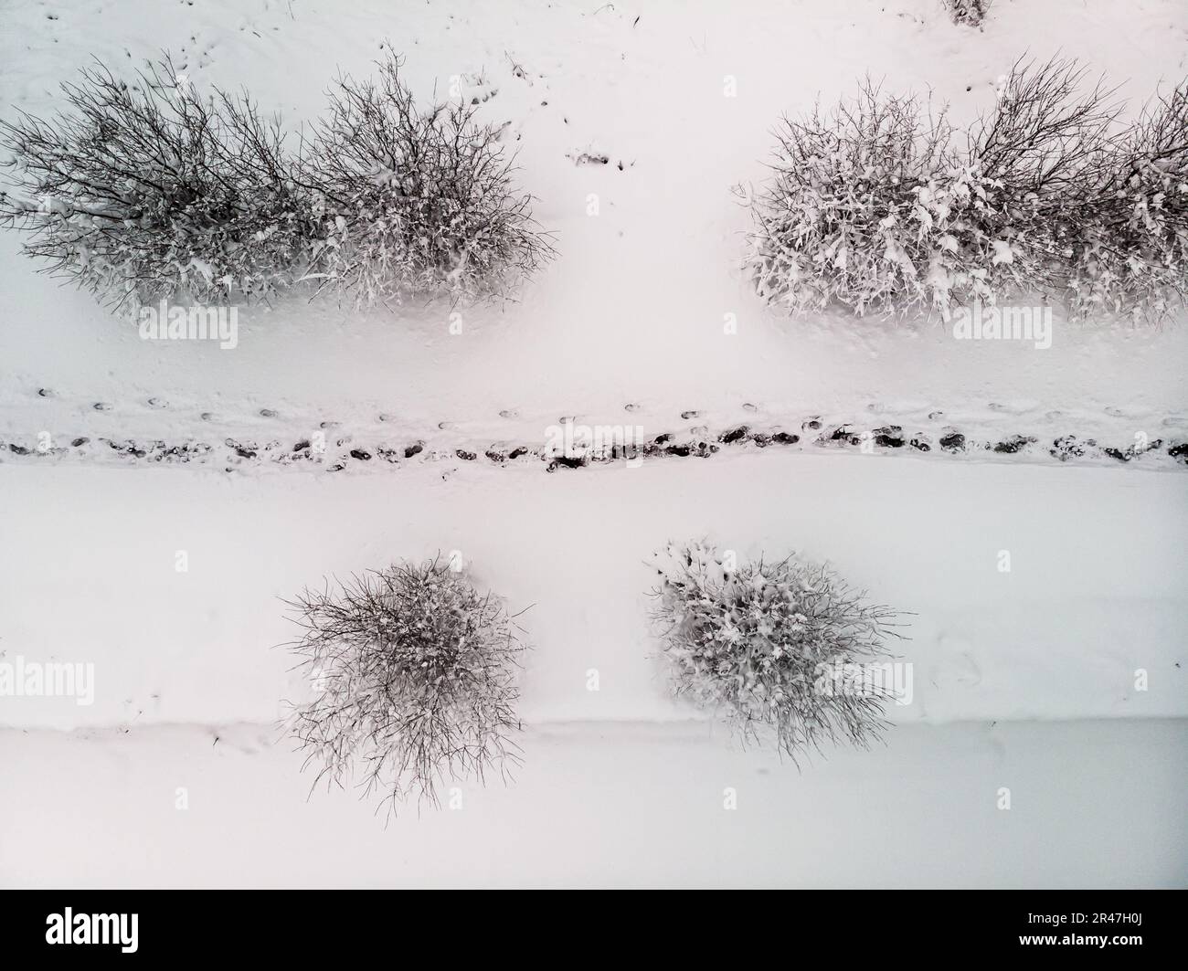 A scenic winter scene featuring a winding country road blanketed in a ...