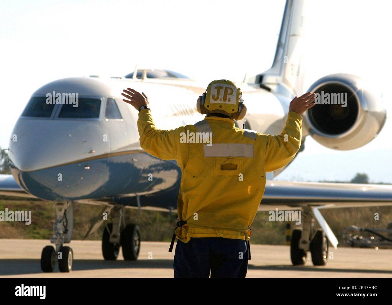 United States Navy aircraft handler directs C-37 Gulfstream V takeoff ...