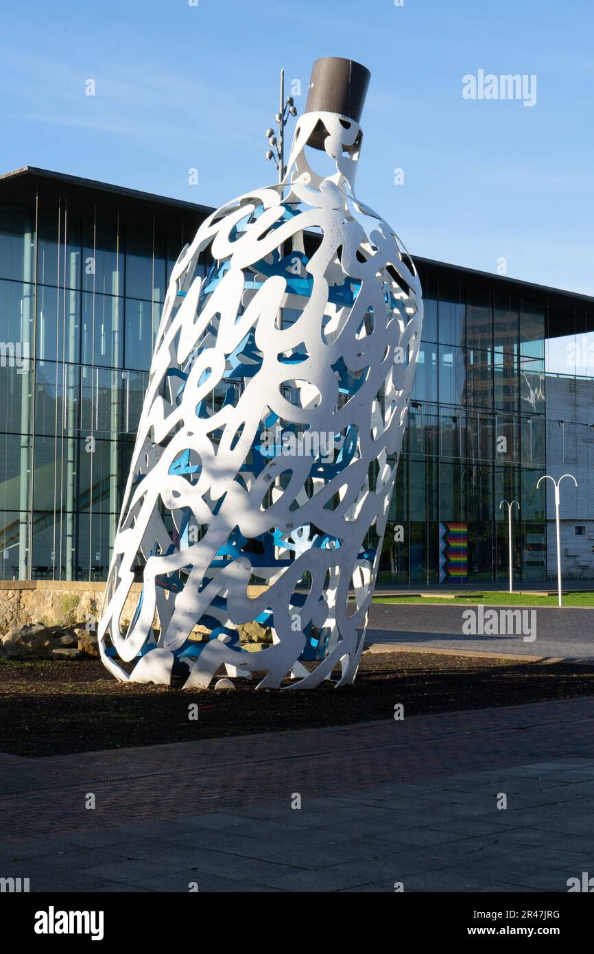 A vibrant, abstract bottle sculpture in front of a museum in ...