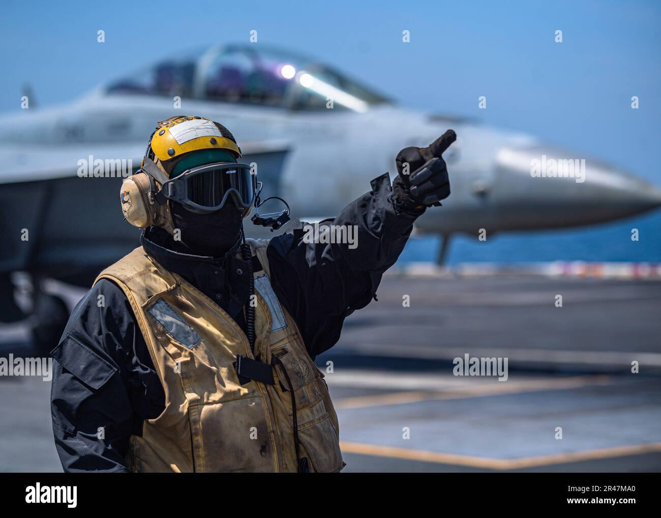 230403-N-MH015-1024 AT SEA (April 3, 2023) A U.S. Navy Sailor directs an aircraft on the flight ...