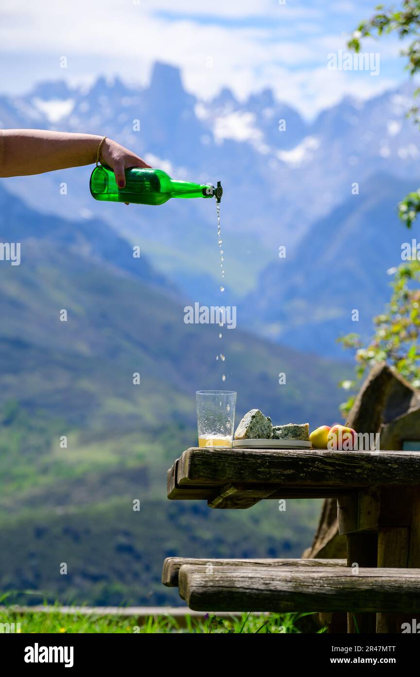 Pouring from high height of natural Asturian cider made from fermented ...