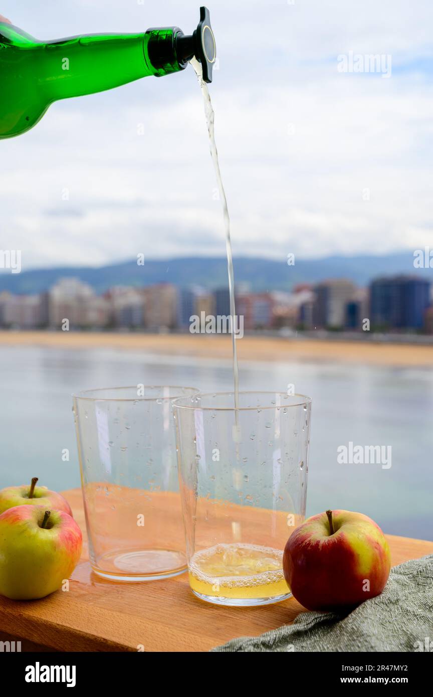 Pouring of natural Asturian cider made from fermented apples in wooden ...