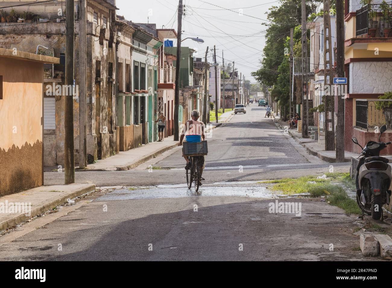 An elderly Cuban man enjoying a sunny day while riding his bicycle down ...
