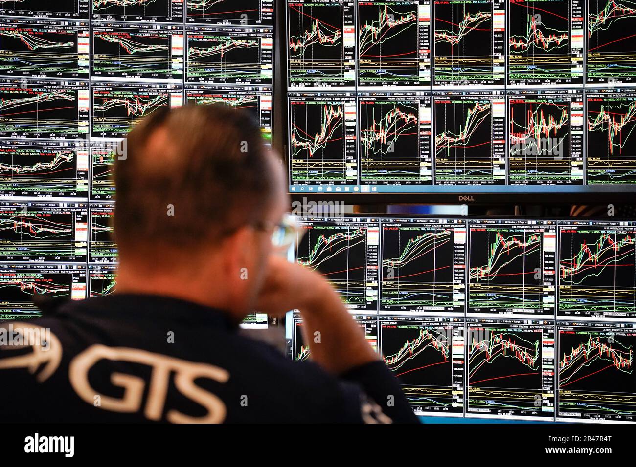 A trader studies a bank of monitors on the floor of the New York Stock ...