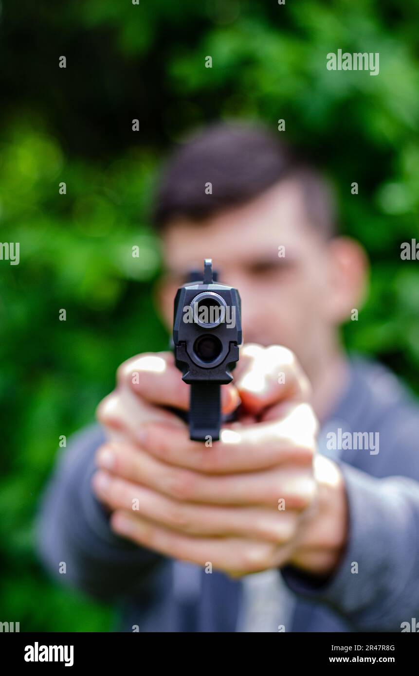 A male shooter aiming with an automatic rifle Stock Photo - Alamy
