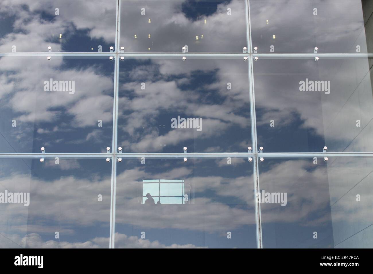 The beautiful blue sky with white clouds reflected in the window glass ...