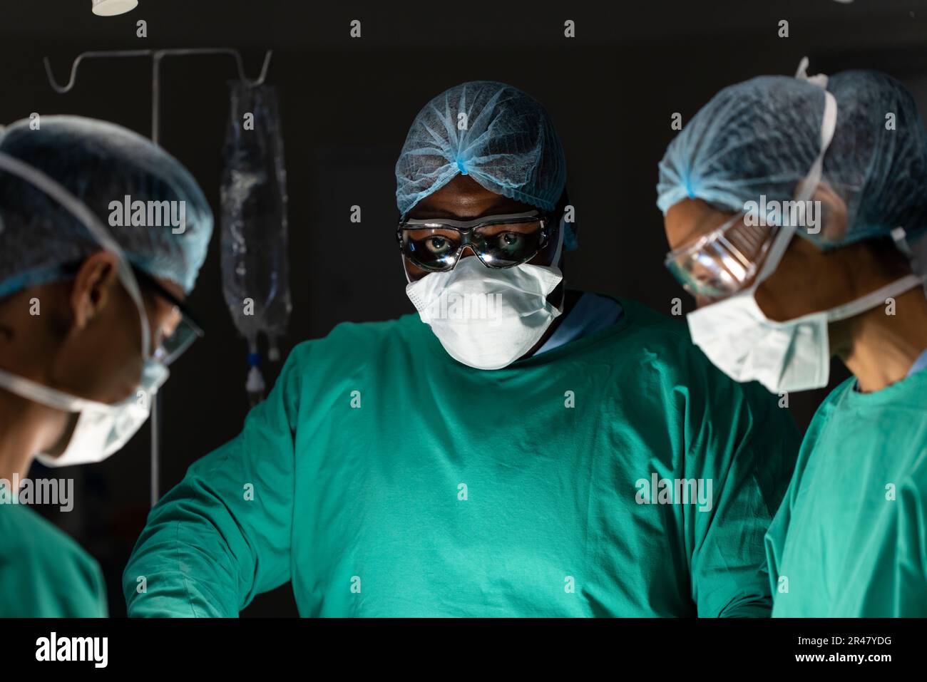 Diverse male and female surgeons operating on patient in operating ...