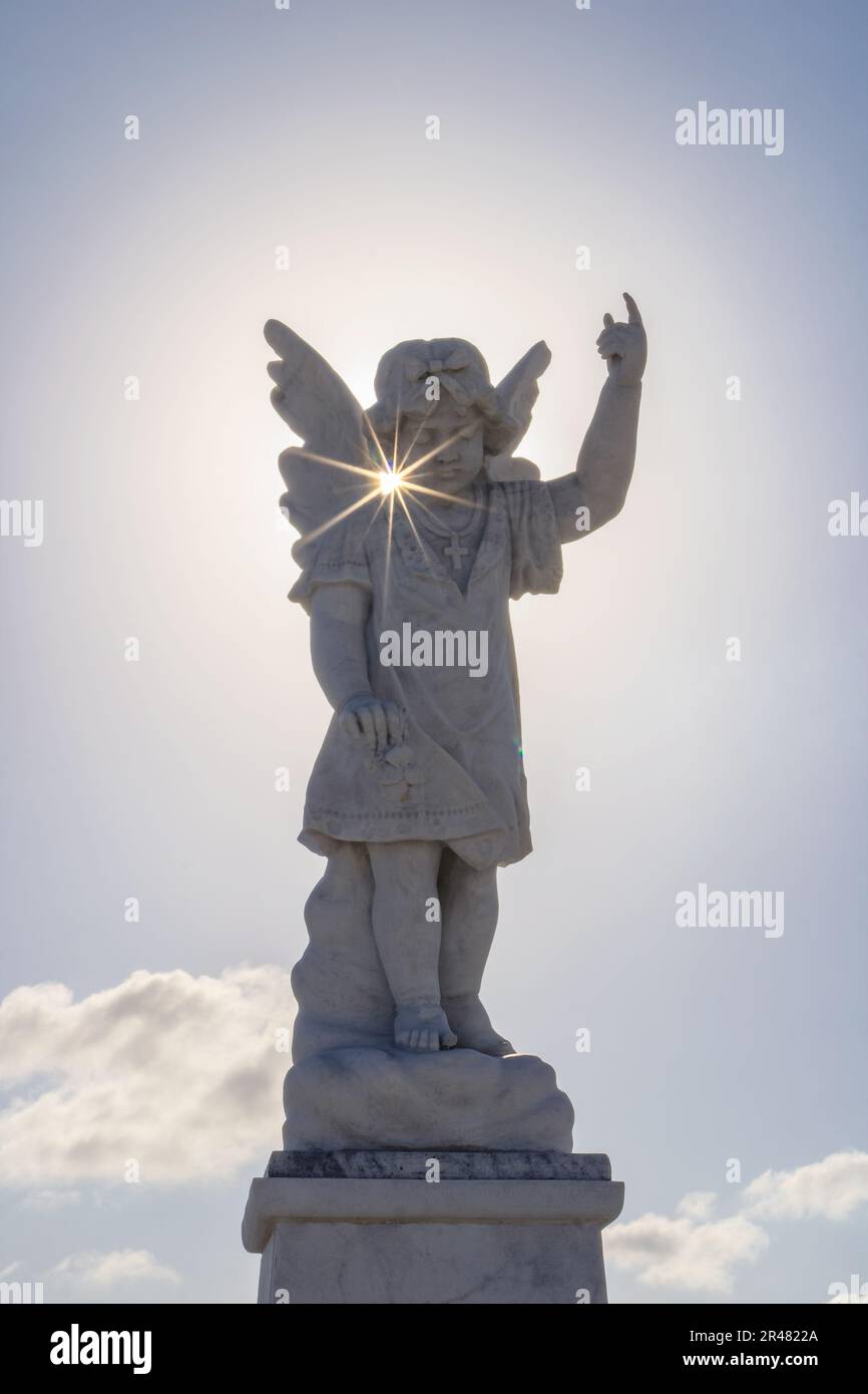 A majestic marble statue of an angel stands atop a pedestal in a ...