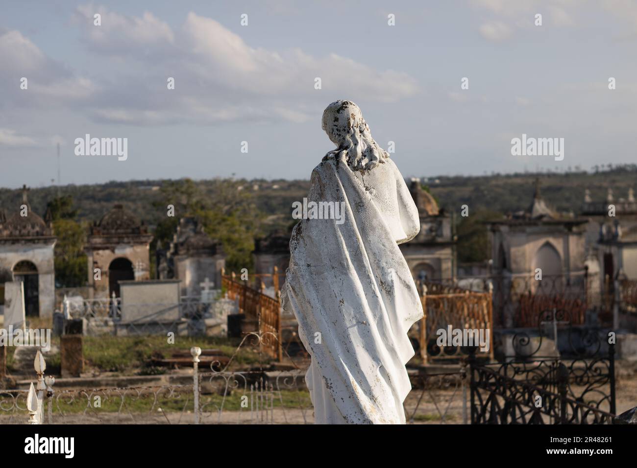 A beautiful statue standing on a hilltop cemetery, with historic ...