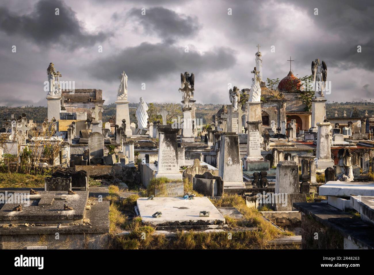 A cemetery with a range of monuments and gravestones, including a tall ...