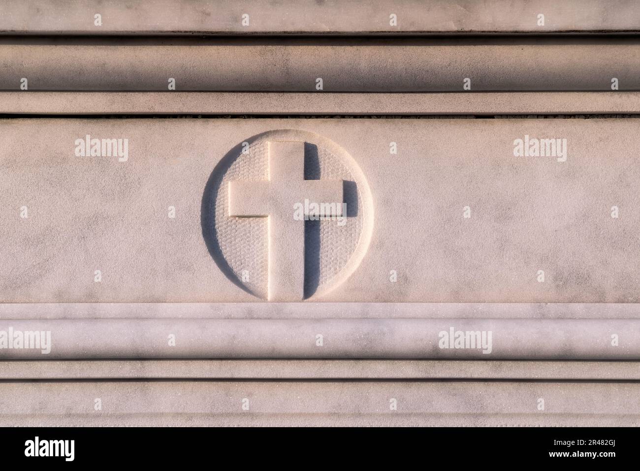 A white stone wall featuring a detailed and intricate cross carving ...