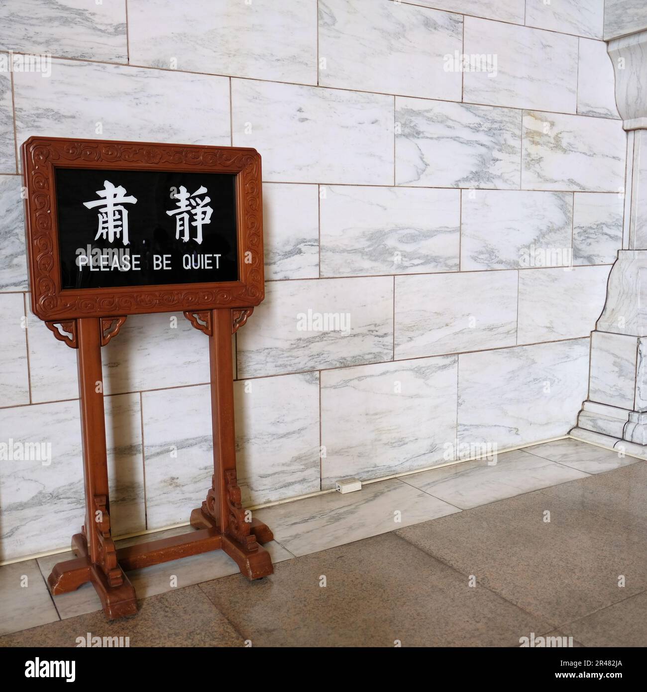 Bilingual English and Chinese Please be quiet sign at the bronze statue ...