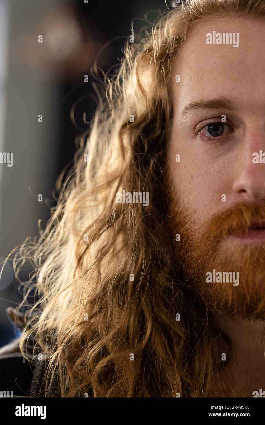 Half portrait of caucasian male customer with long curly red hair and ...