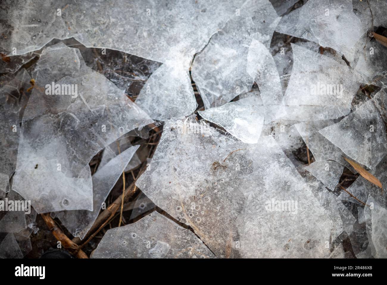 A winter scene featuring icy ground with broken ice pieces scattered ...
