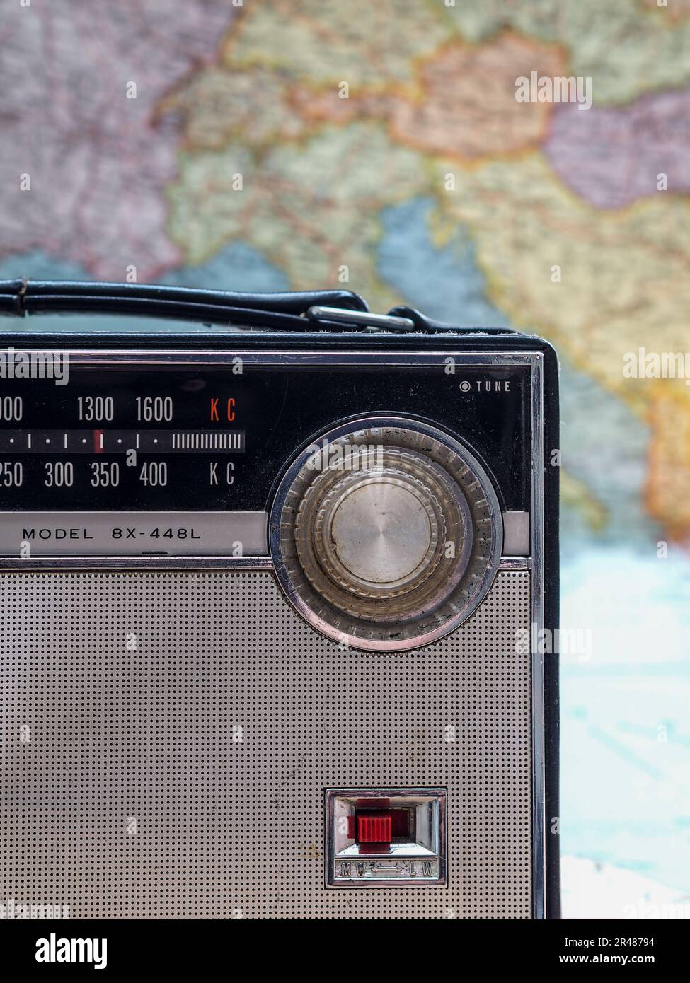 A vertical closeup shot of a vintage transistor radio on a map ...