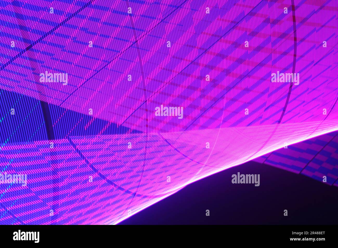 A large display featuring a pattern of pink lights radiating outward ...