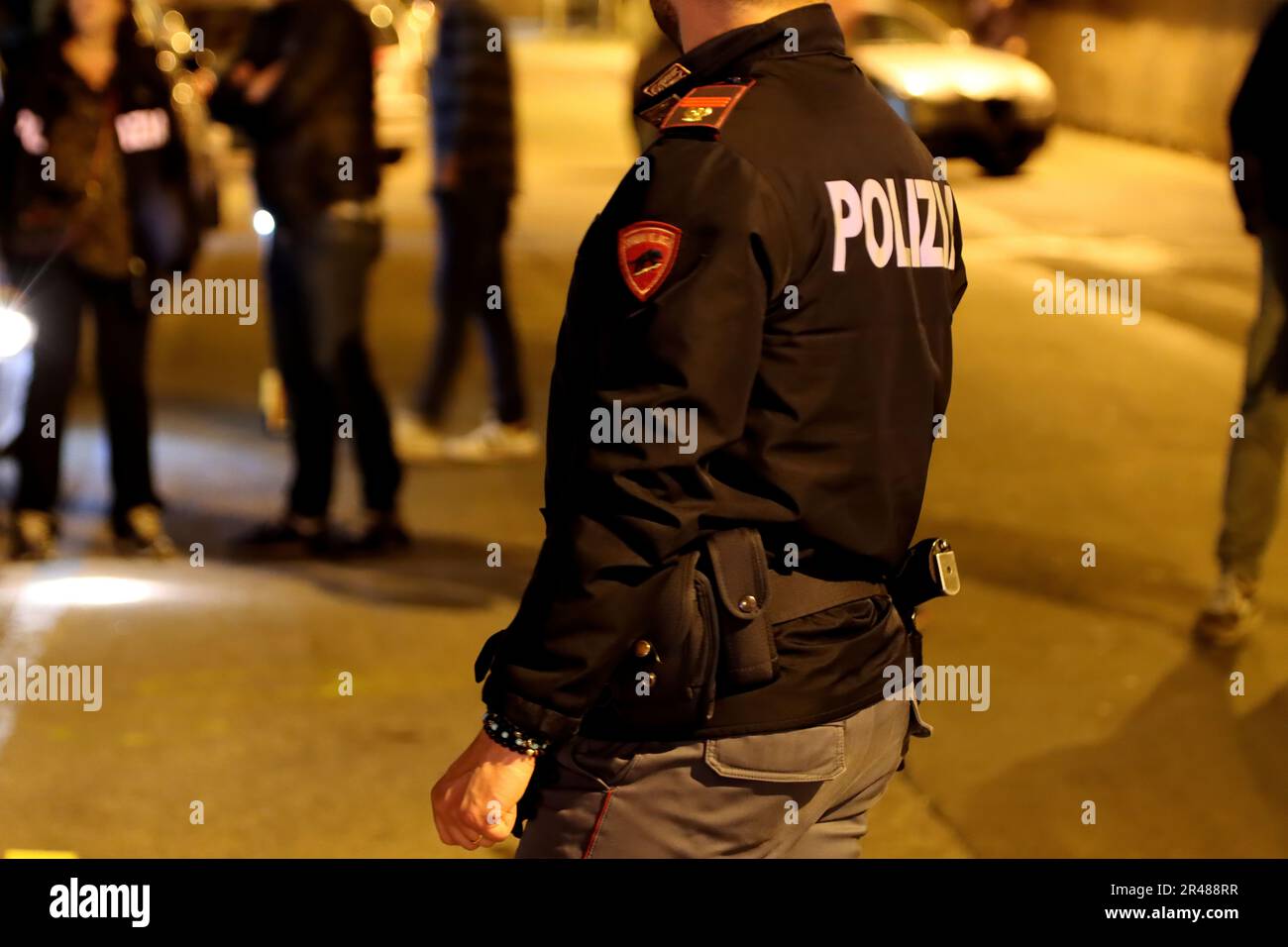 Italian police officers investigating a nighttime murder scene. Italian ...