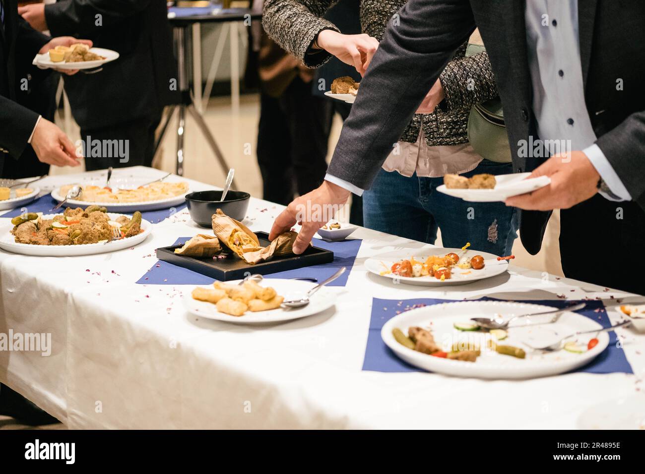 People in suits serve themselves at the buffet and eat delicious food ...
