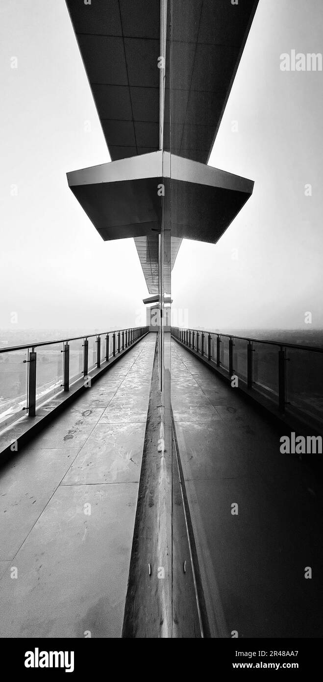 A monochrome bridge extending over a body of water, with the shoreline ...