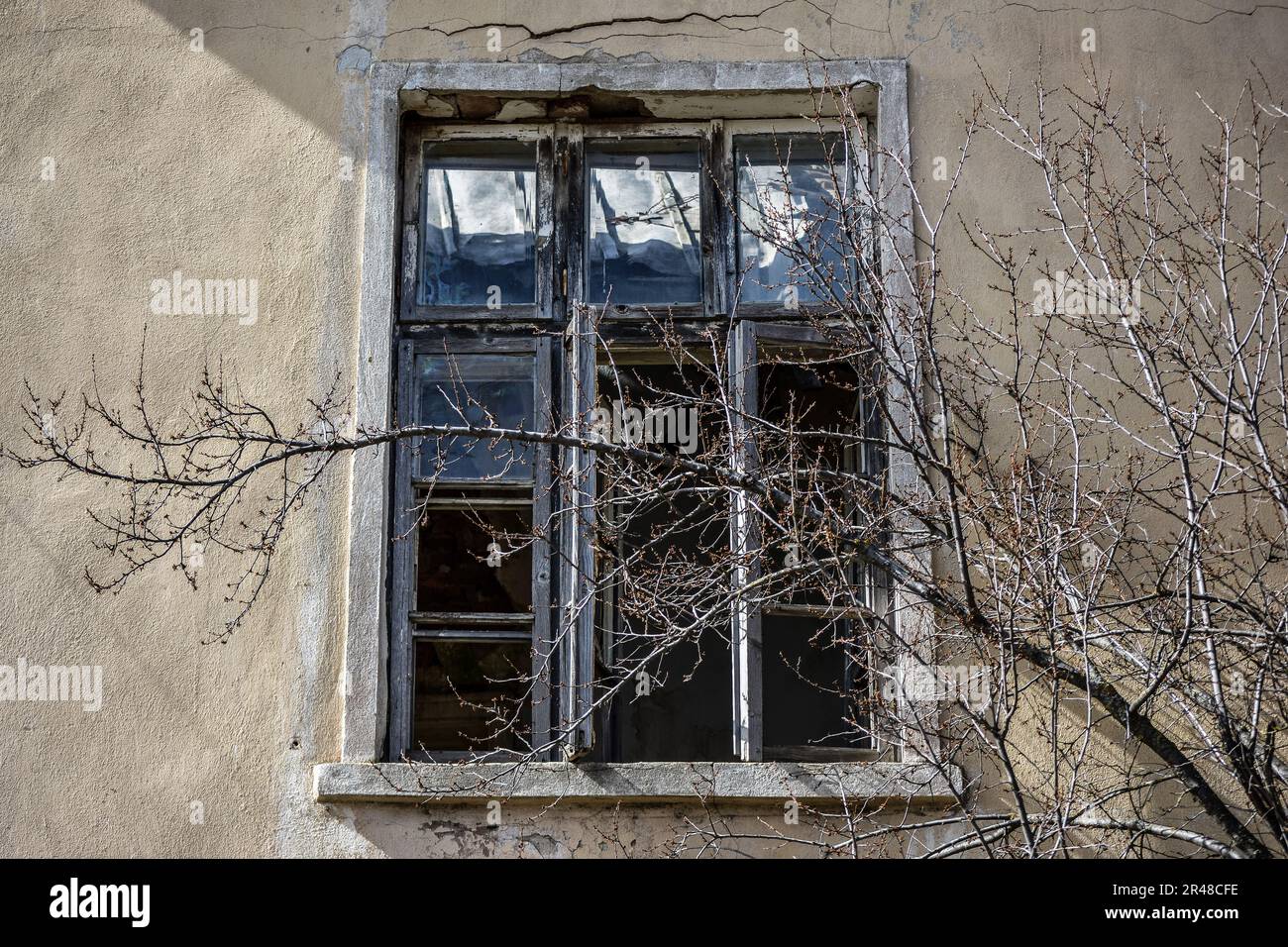 An exterior view of an aged building featuring a damaged window ...