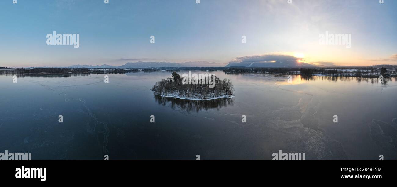 A picturesque winter scene of a small island with snow and ice covering ...