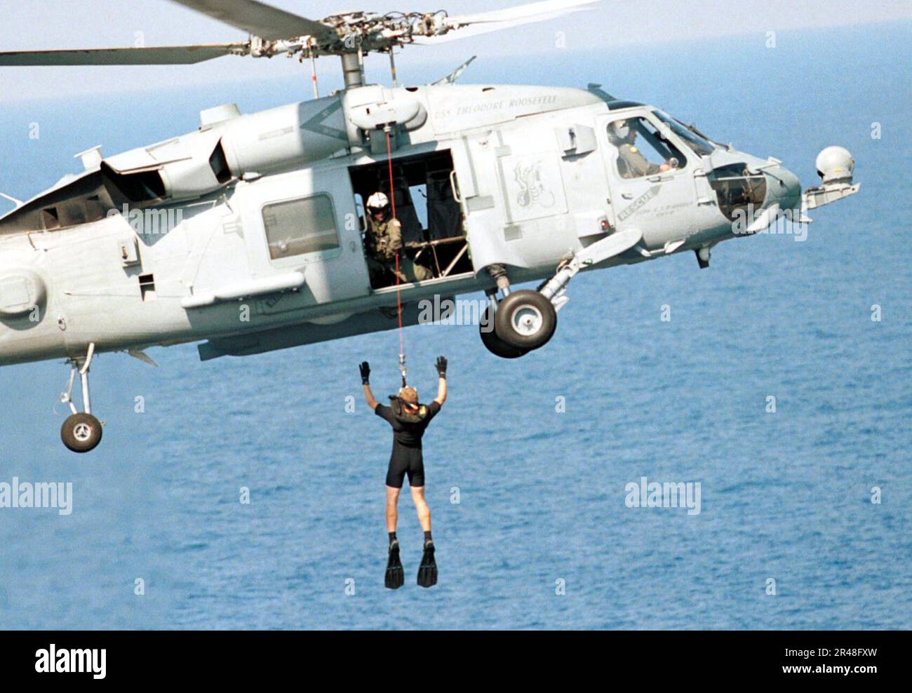 US Navy Search and Rescue swimmer is lowered from a helicopter Stock ...