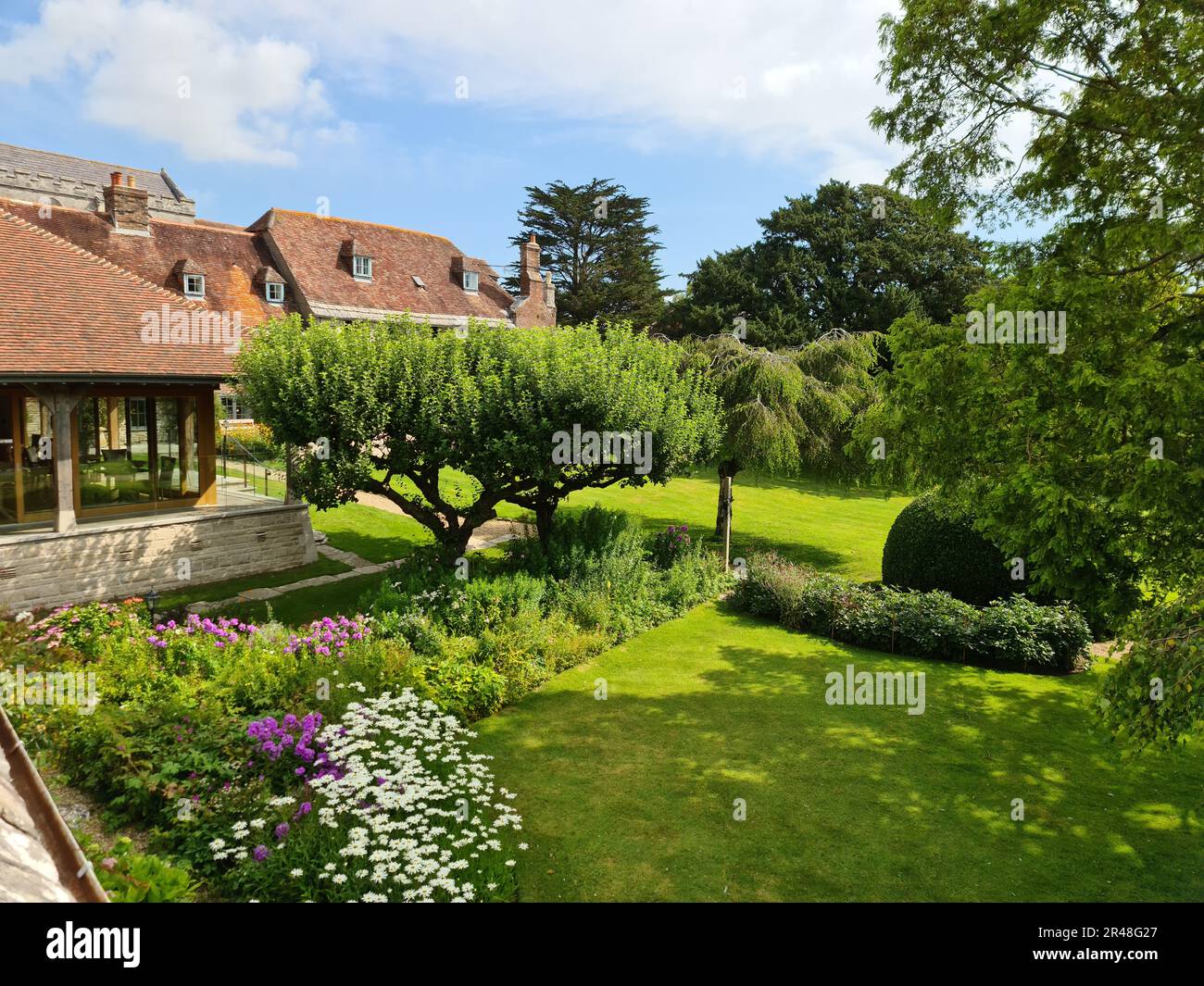 A picturesque garden with a vibrant green lawn and a variety of white ...