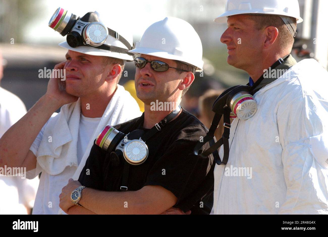 US Navy Rescue workers watch the flag being draped over the side of the ...