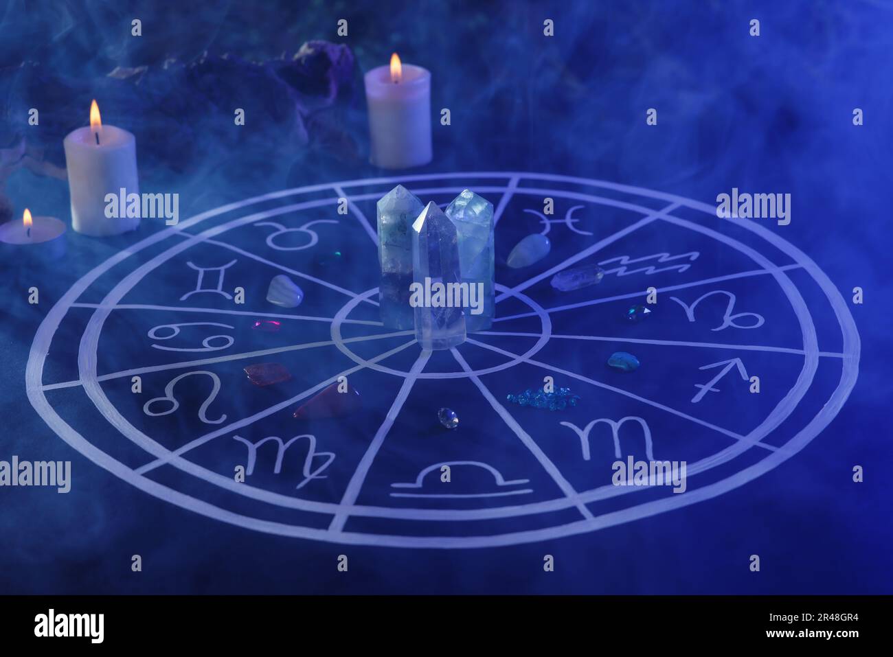 Natural stones for zodiac signs, drawn astrology chart and burning ...