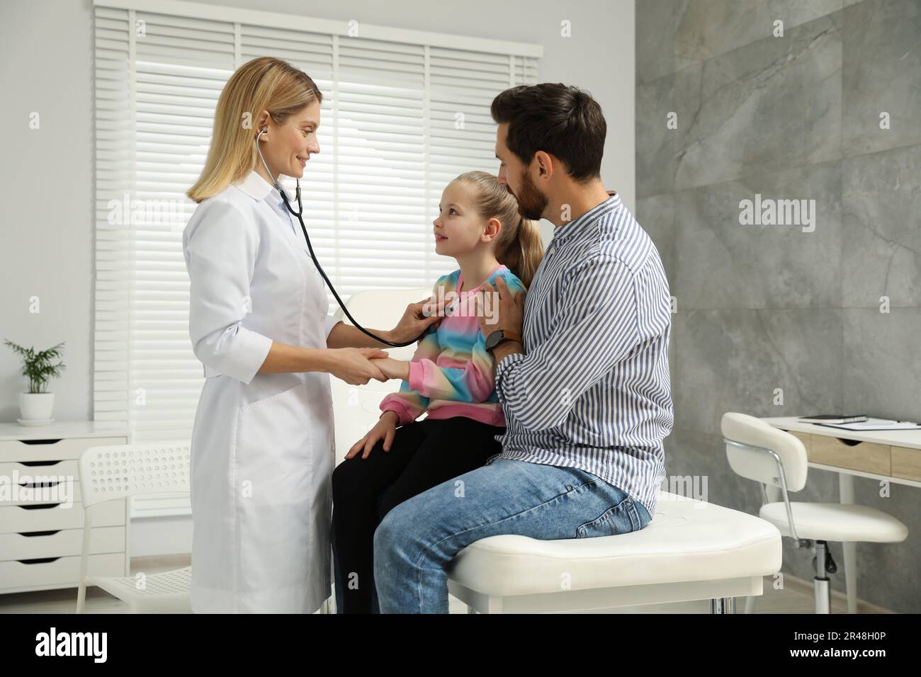 Father and daughter having appointment with doctor. Pediatrician ...