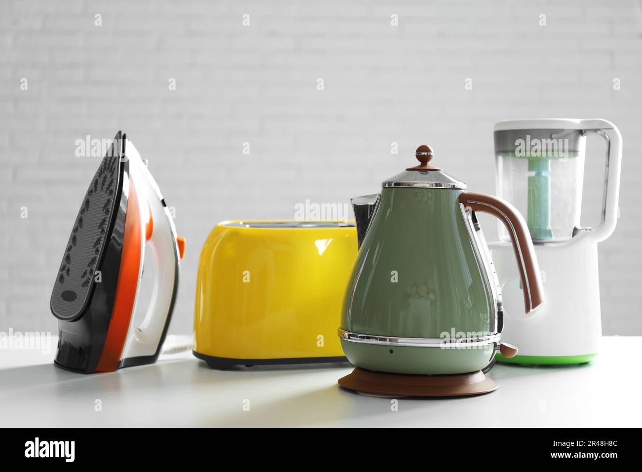 Set of modern home appliances on white table Stock Photo - Alamy