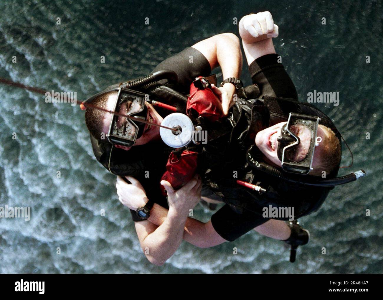 US Navy Search and Rescue (SAR) swimmers are hoisted into a SH-60F ...