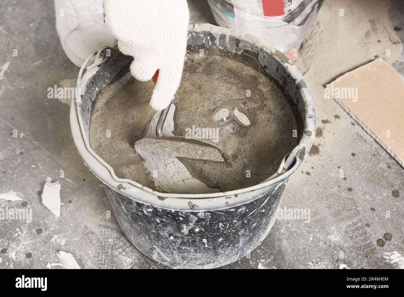 Person mixing cement in bucket hi-res stock photography and images - Alamy