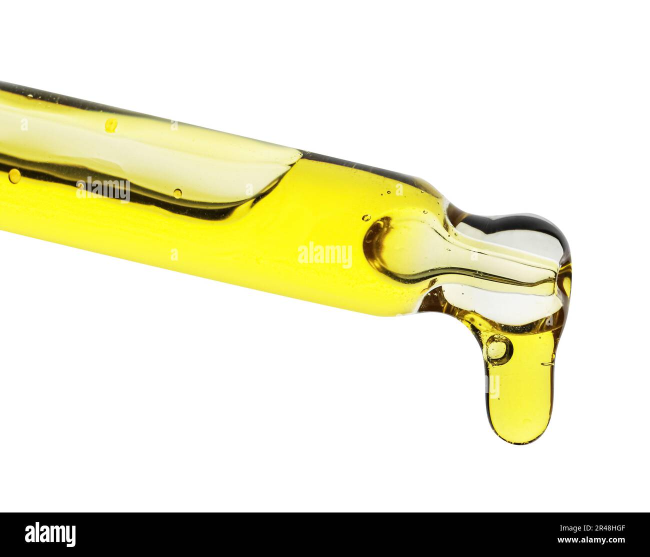 Dripping yellow facial serum from pipette on white background, closeup ...