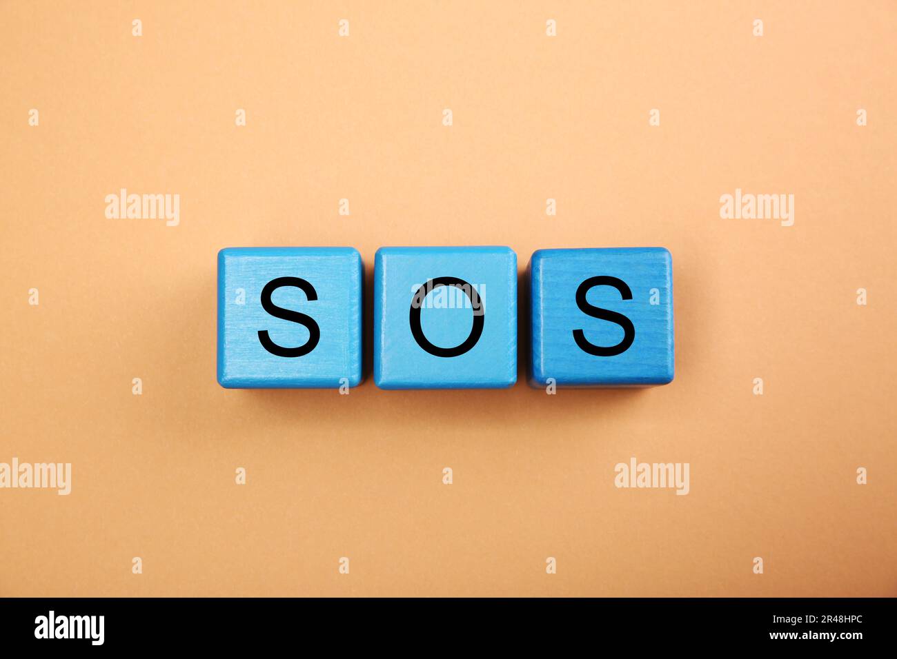 Abbreviation SOS (Save Our Souls) made of light blue cubes with letters ...