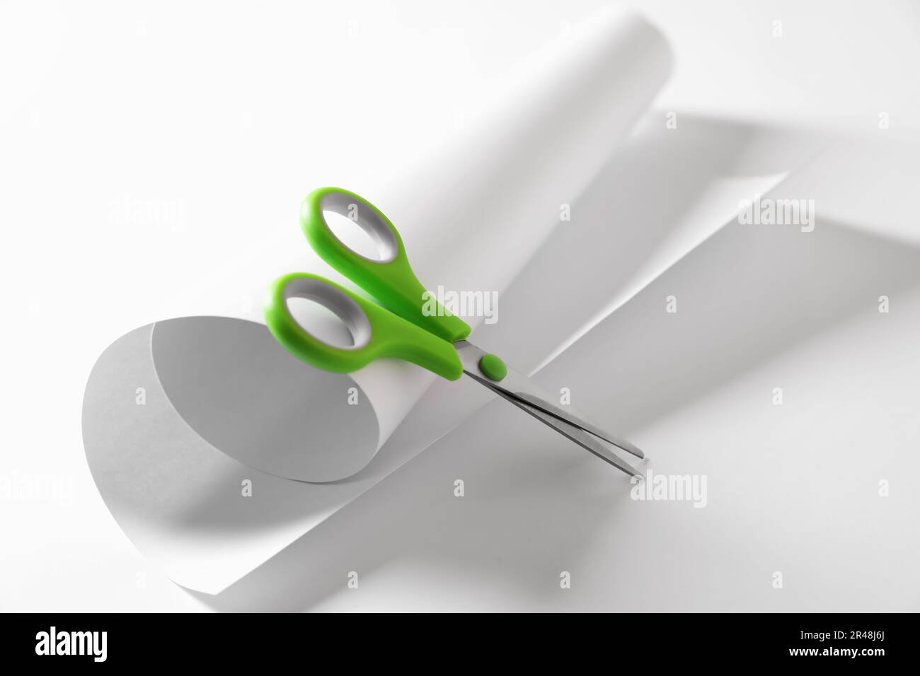 Green scissors and paper on white background Stock Photo - Alamy