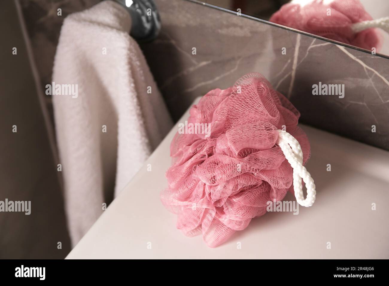 Pink shower puff on washbasin in bathroom Stock Photo - Alamy