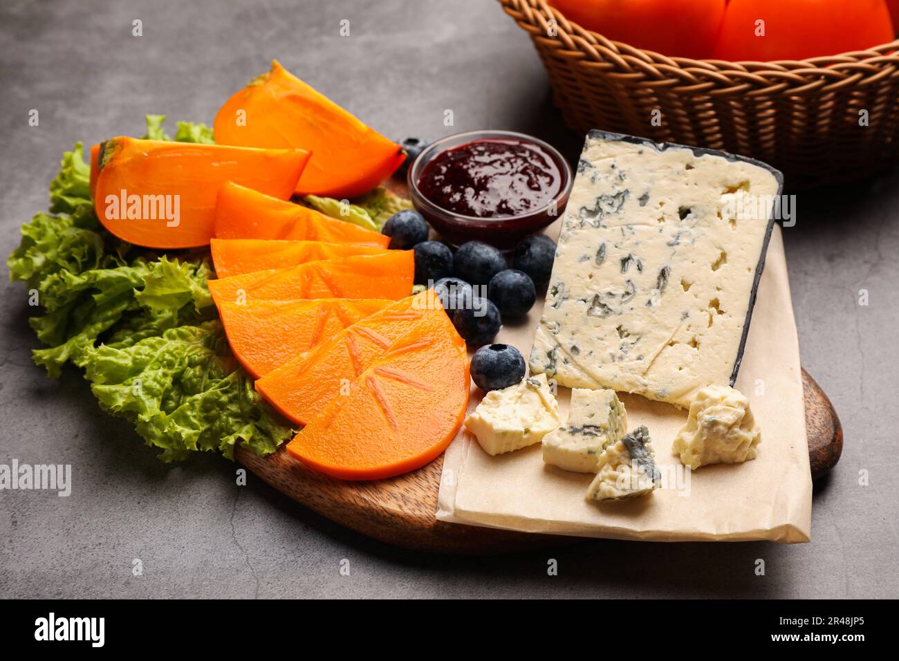 Delicious persimmon, blue cheese, blueberries and jam served on light ...