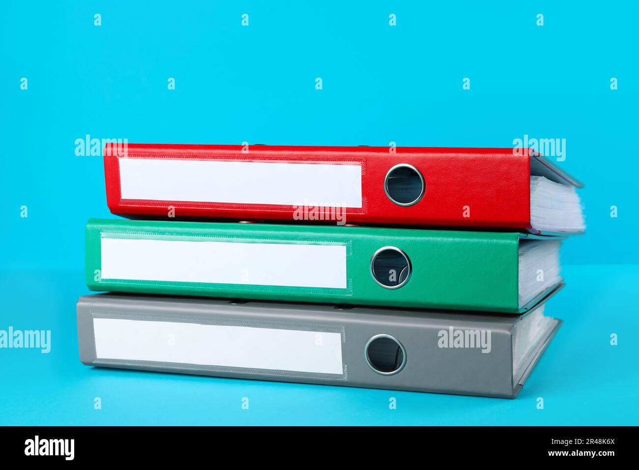 Stack of office folders on light blue background Stock Photo - Alamy