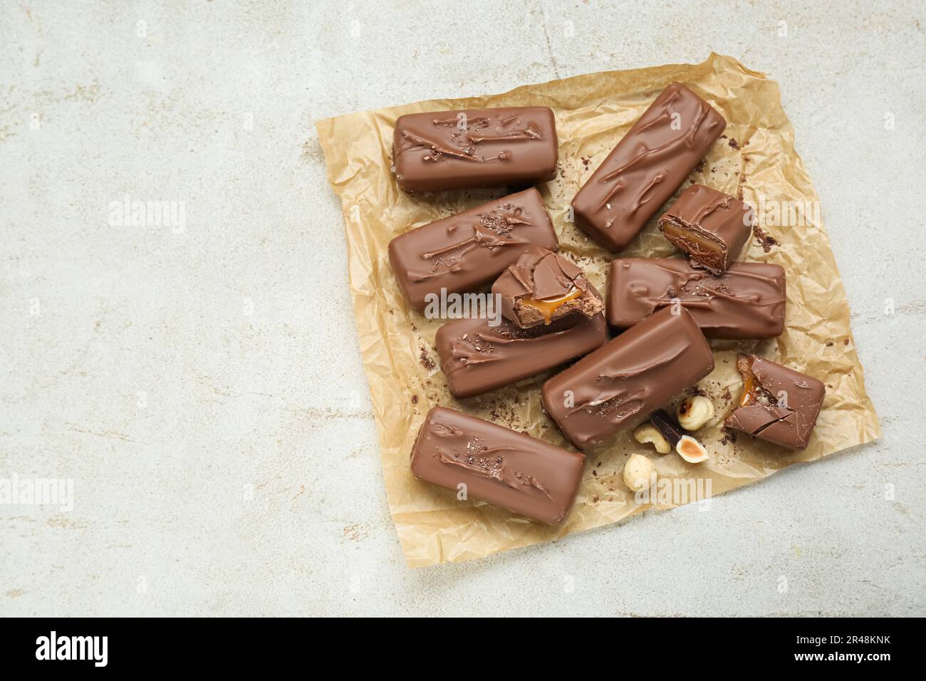 Delicious chocolate candy bars with caramel and nuts on light table ...