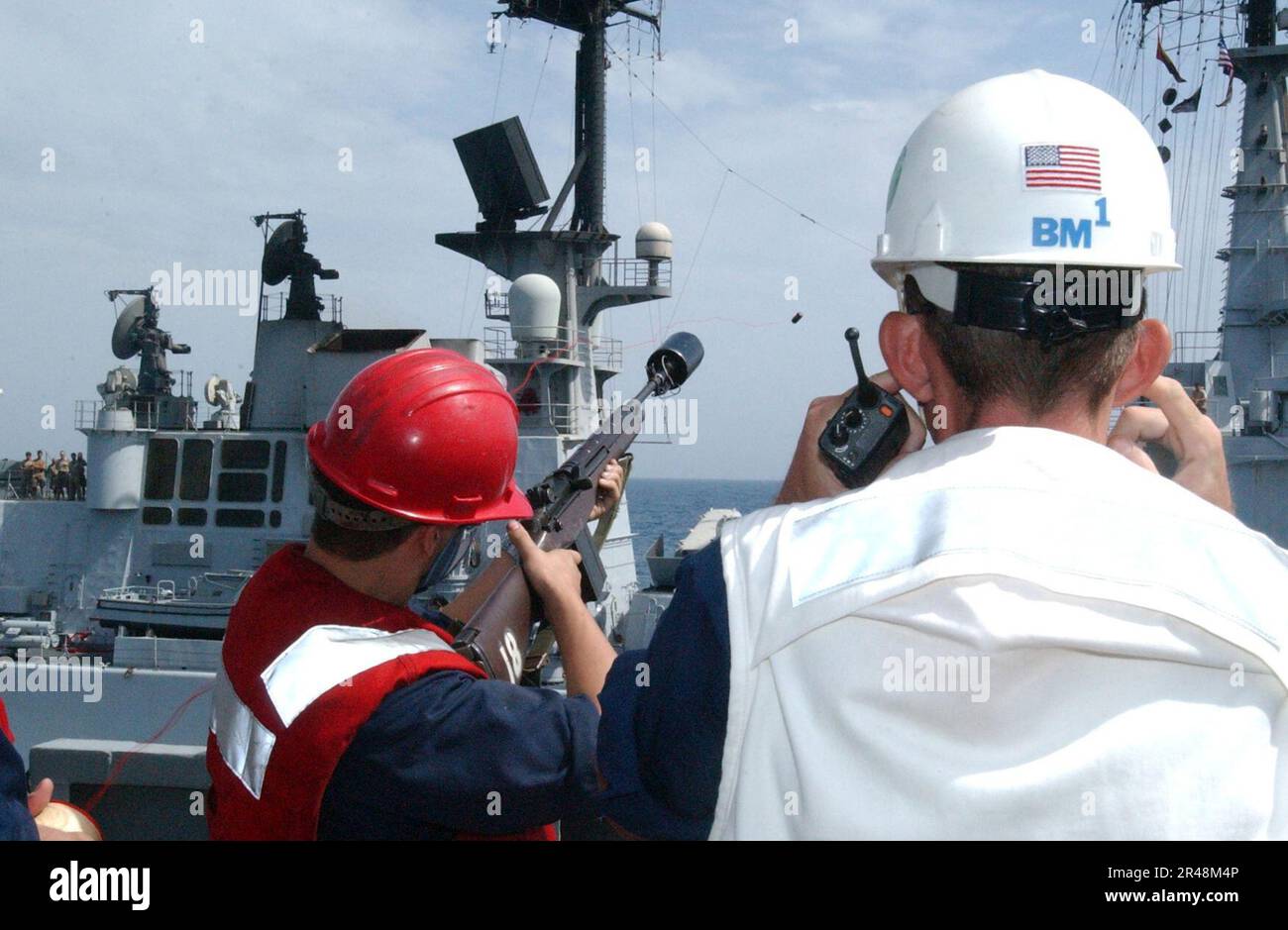 US Navy Sailor fires a shot-line to ship along side during ...