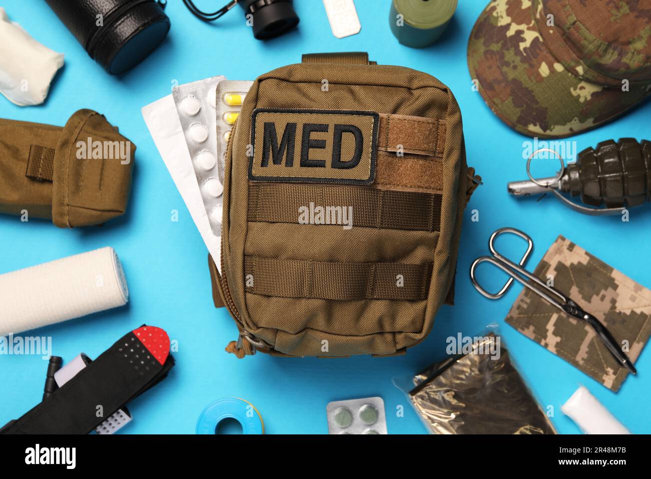 Military first aid kit and equipment on light blue background, flat lay ...